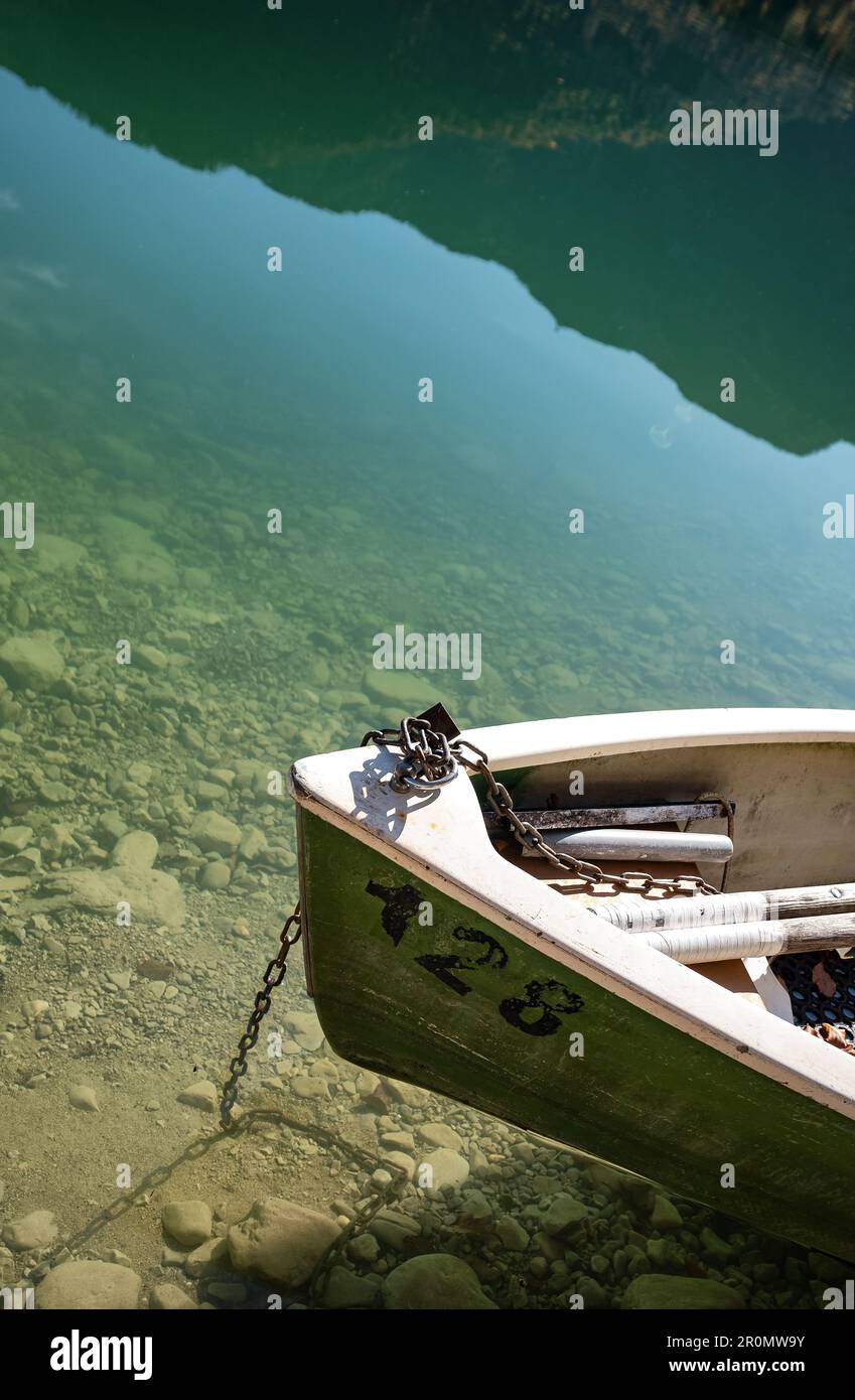 Bow of rowboat on the Sylvensteinsee, mirroring mountains in the upper ...