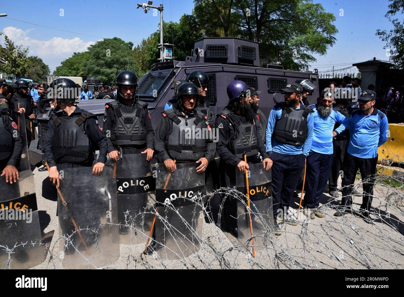 Pakistan's riot police officers stand guard next to an armored vehicle ...