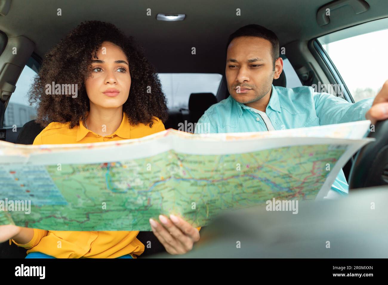 Confused Middle Eastern Couple Holding Paper Map Sitting In Car Stock ...