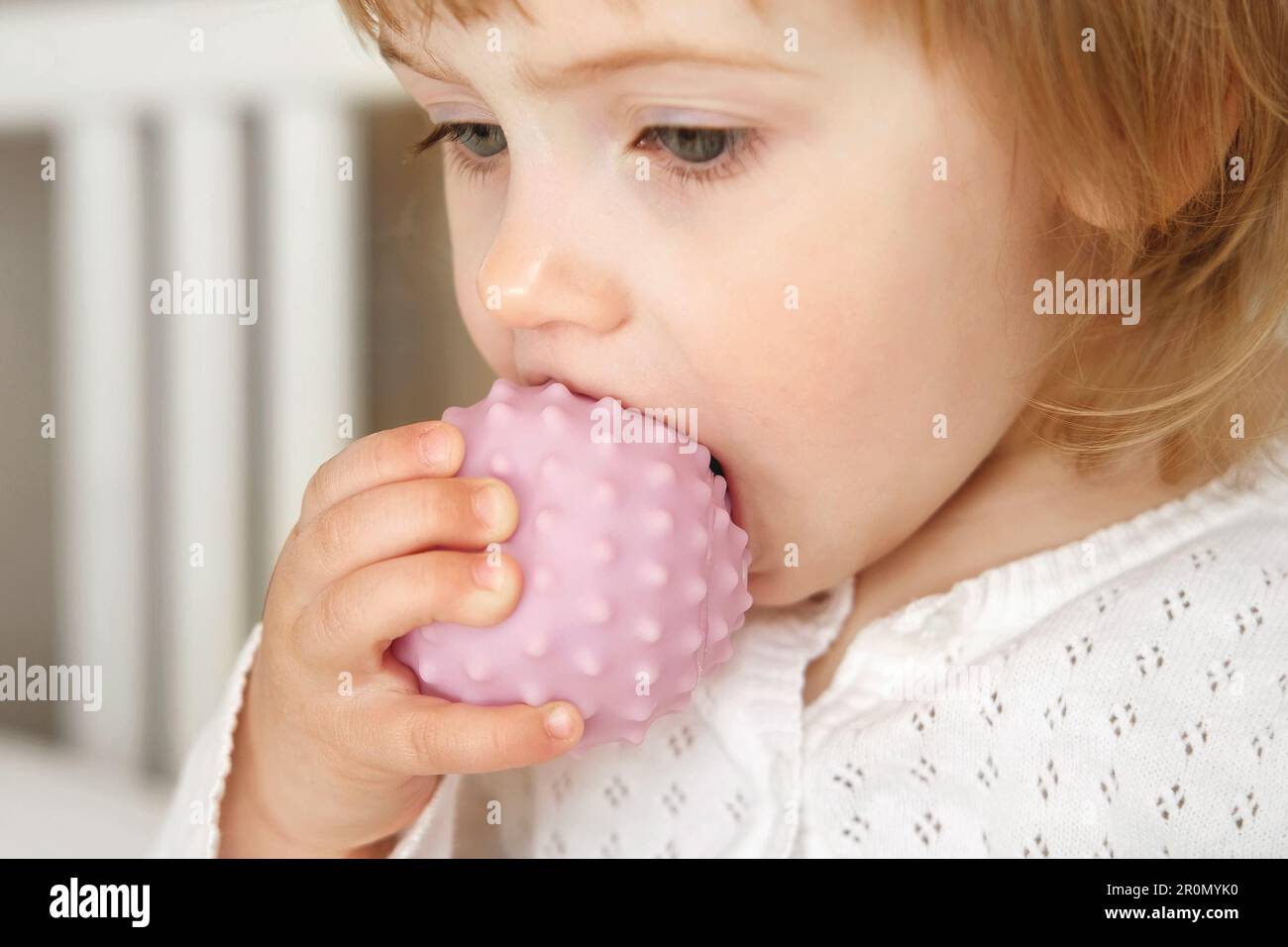 Cute baby girl playing tactile wooden and silicone toys. Young child ...