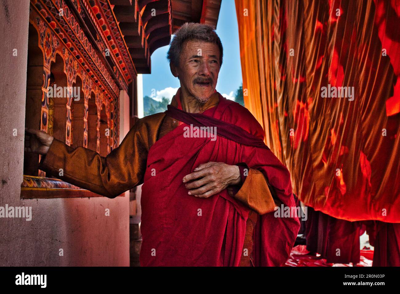 Old monk behind the Great Thanka at festival in Gangteng Monastery ...