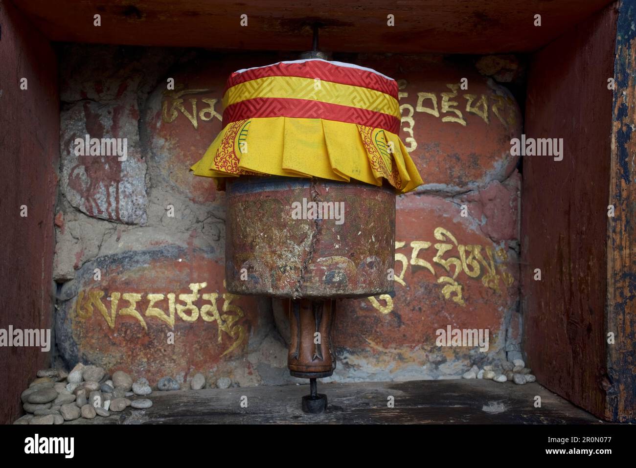Prayer wheel with the mantra Om Mani Padme Hum in Tibetan scripture in ...