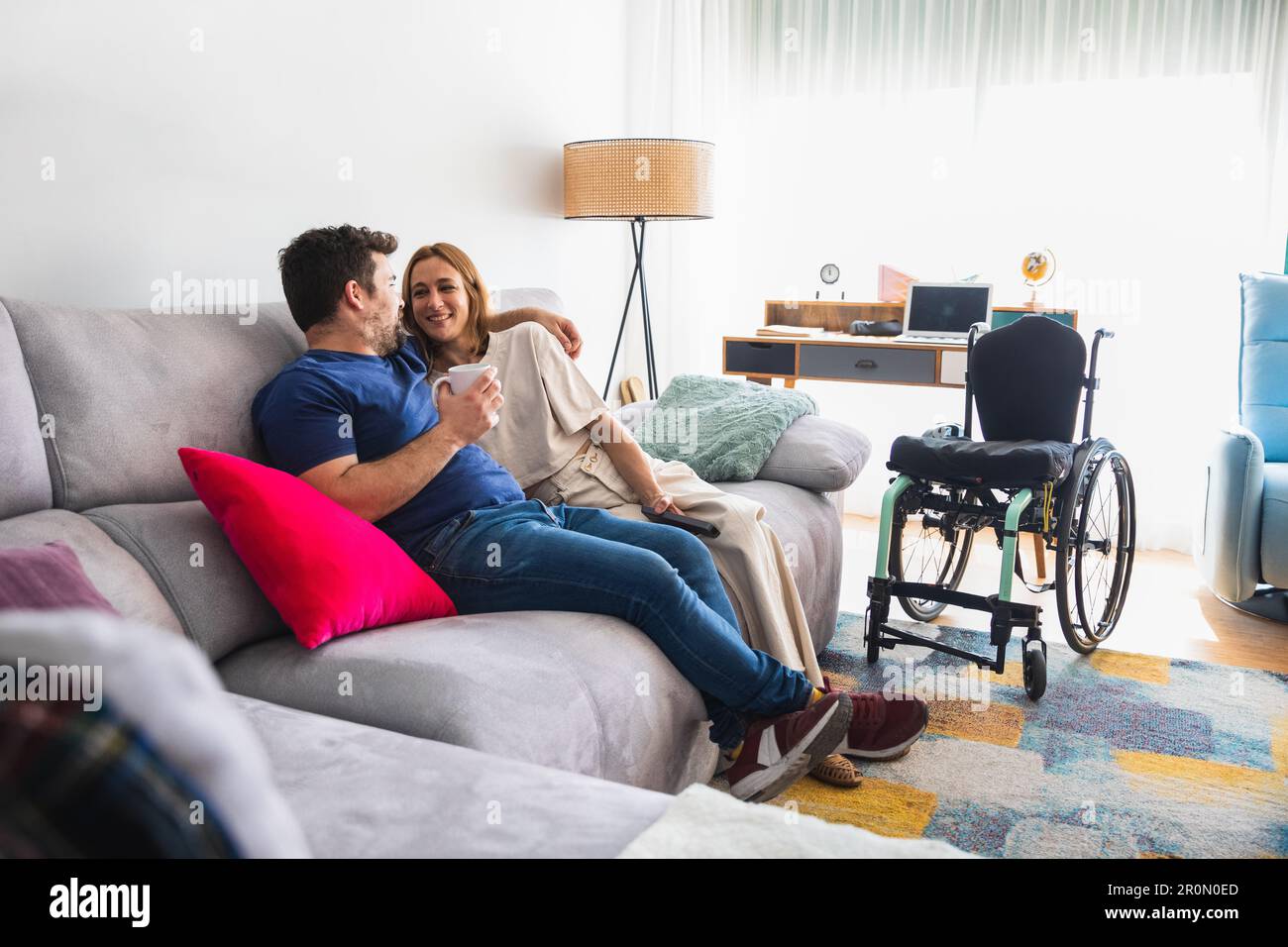 Loving couple cuddling and relaxing together on comfortable sofa in ...