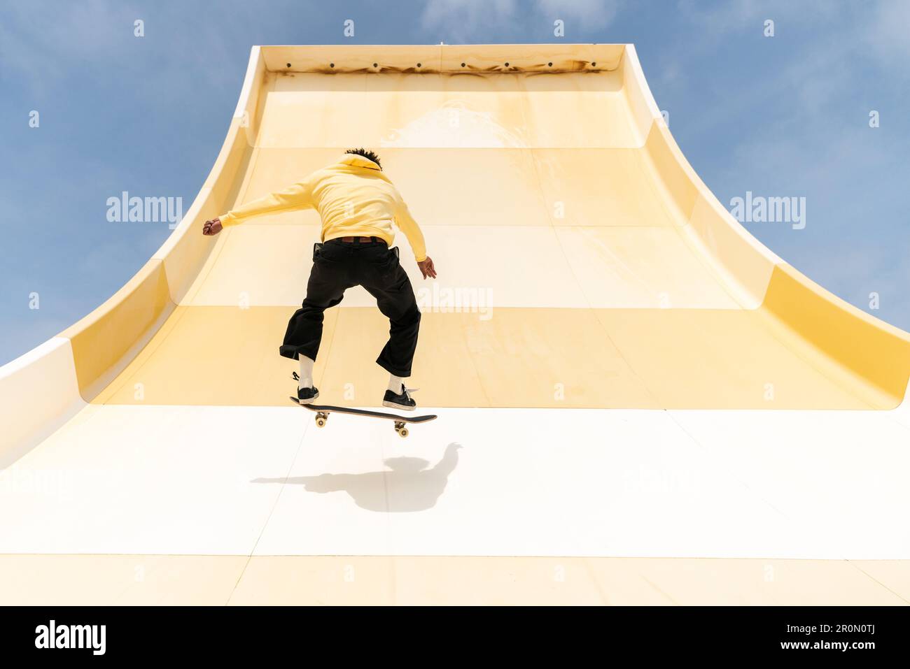 Back view of full body African American male skater in casual clothes ...