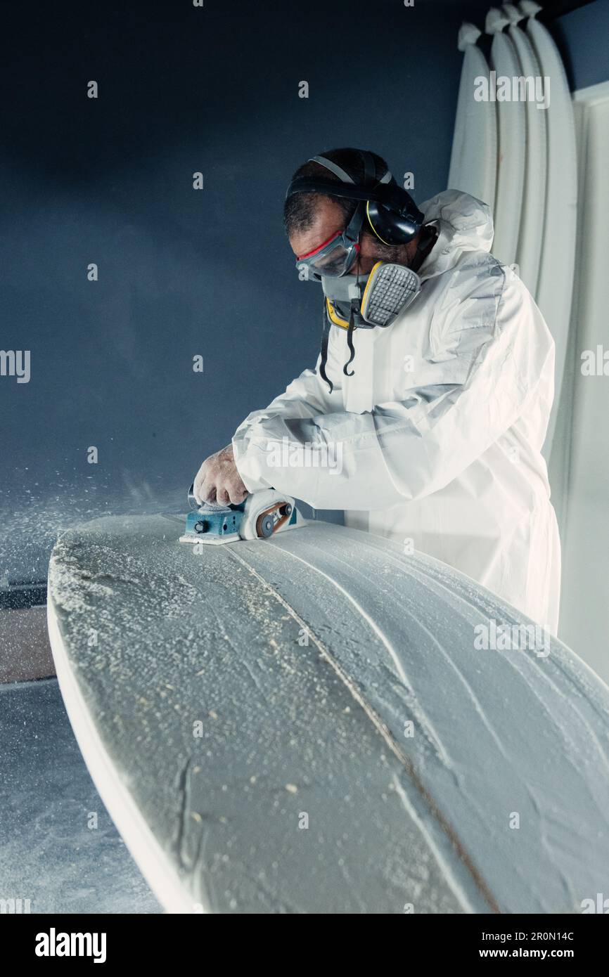 Side view of focused male master in protective respirator and uniform ...