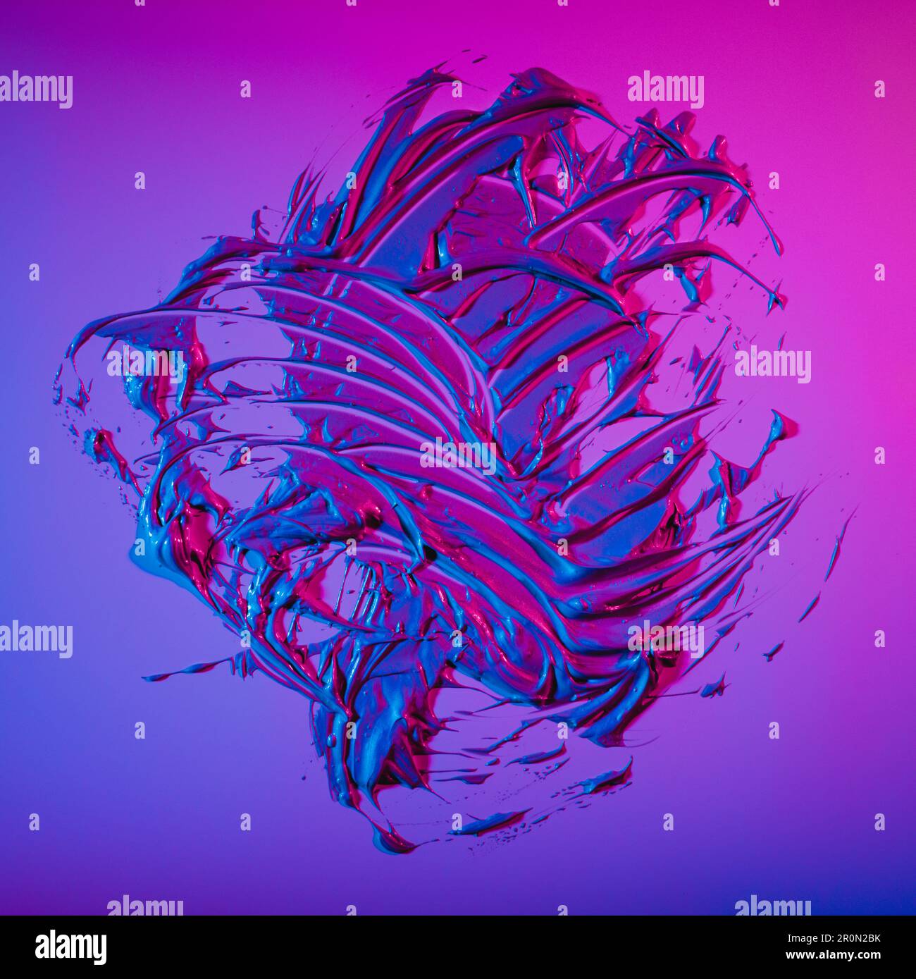 From above puddle of bright neon acrylic paint spread on vivid purple ...