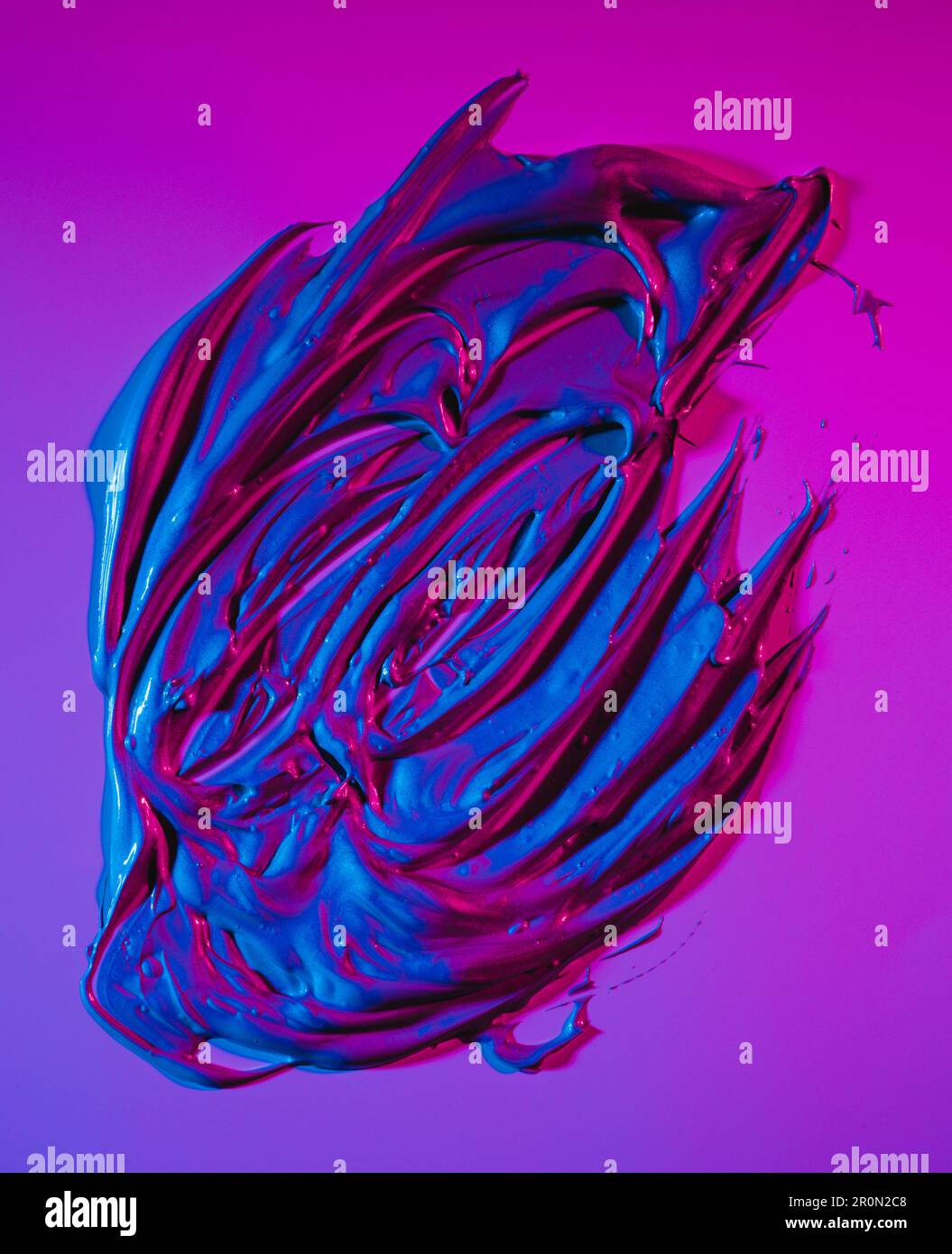 From above puddle of bright neon acrylic paint spread on vivid purple ...