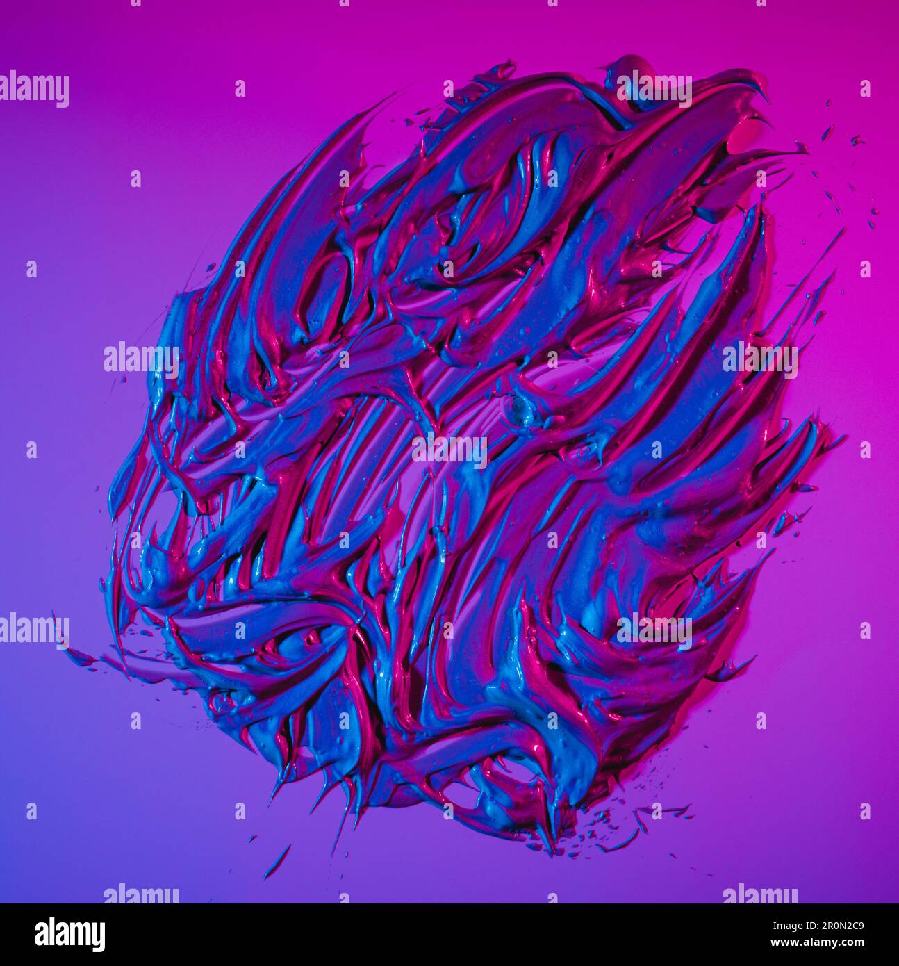 From above puddle of bright neon acrylic paint spread on vivid purple ...