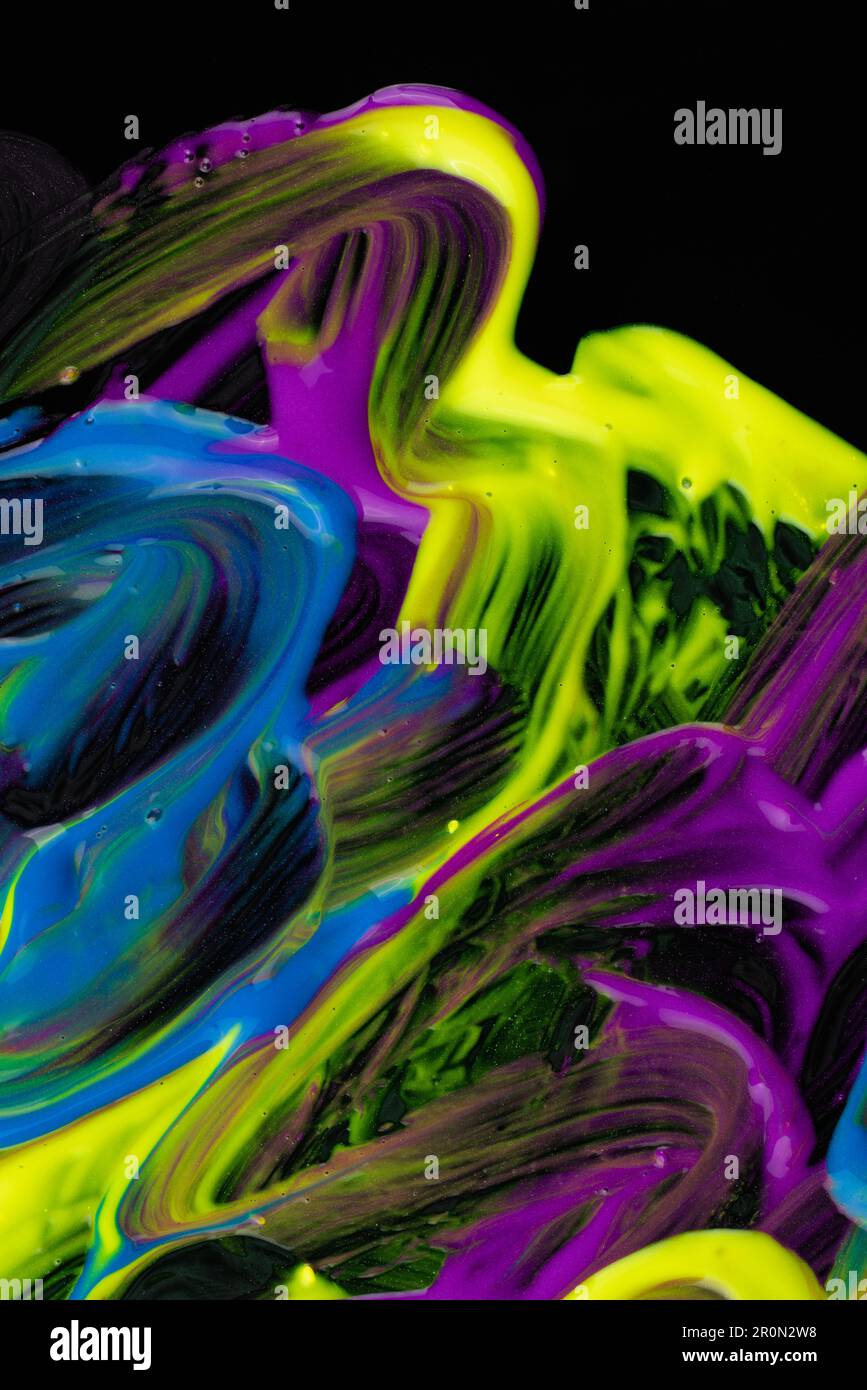 Closeup shot of spills of thick pigment of various colors mixing on ...