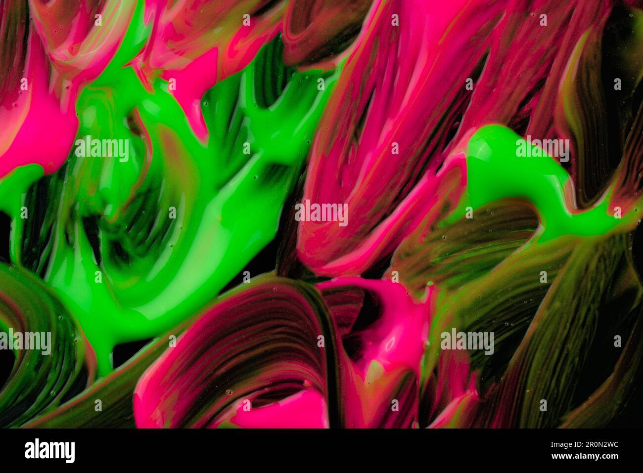 Closeup shot of spills of thick pigment of various colors mixing on ...