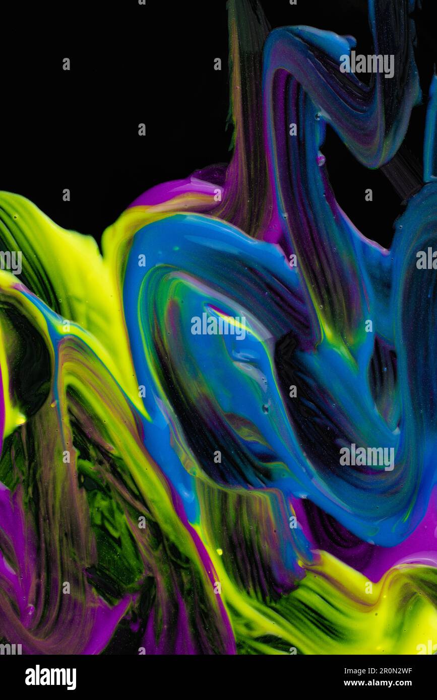 Closeup shot of spills of thick pigment of various colors mixing on ...