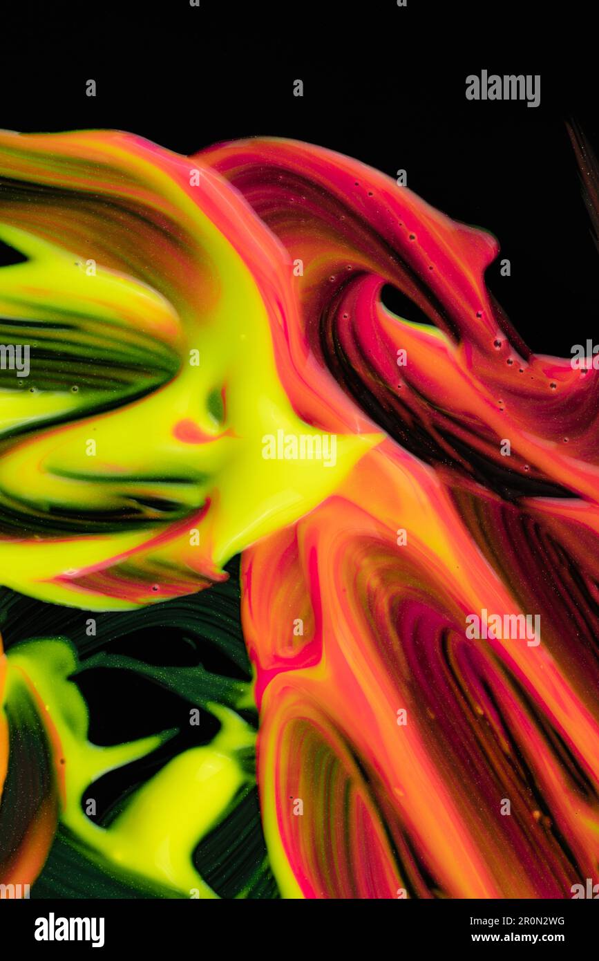 Closeup shot of spills of thick pigment of various colors mixing on ...