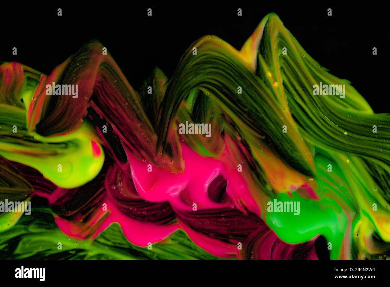 Closeup shot of spills of thick pigment of various colors mixing on ...