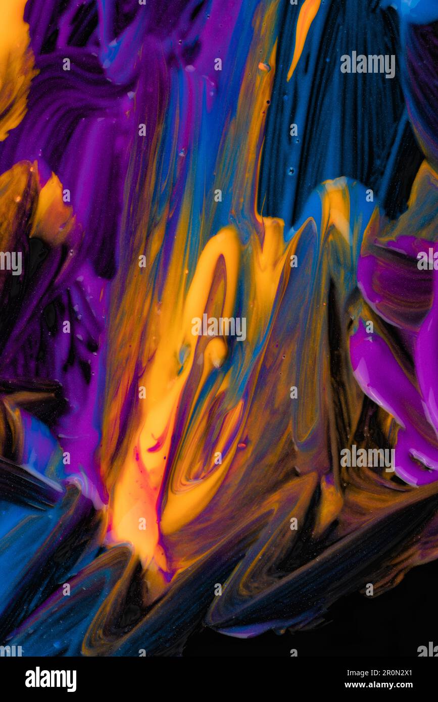 Closeup shot of spills of thick pigment of various colors mixing on ...