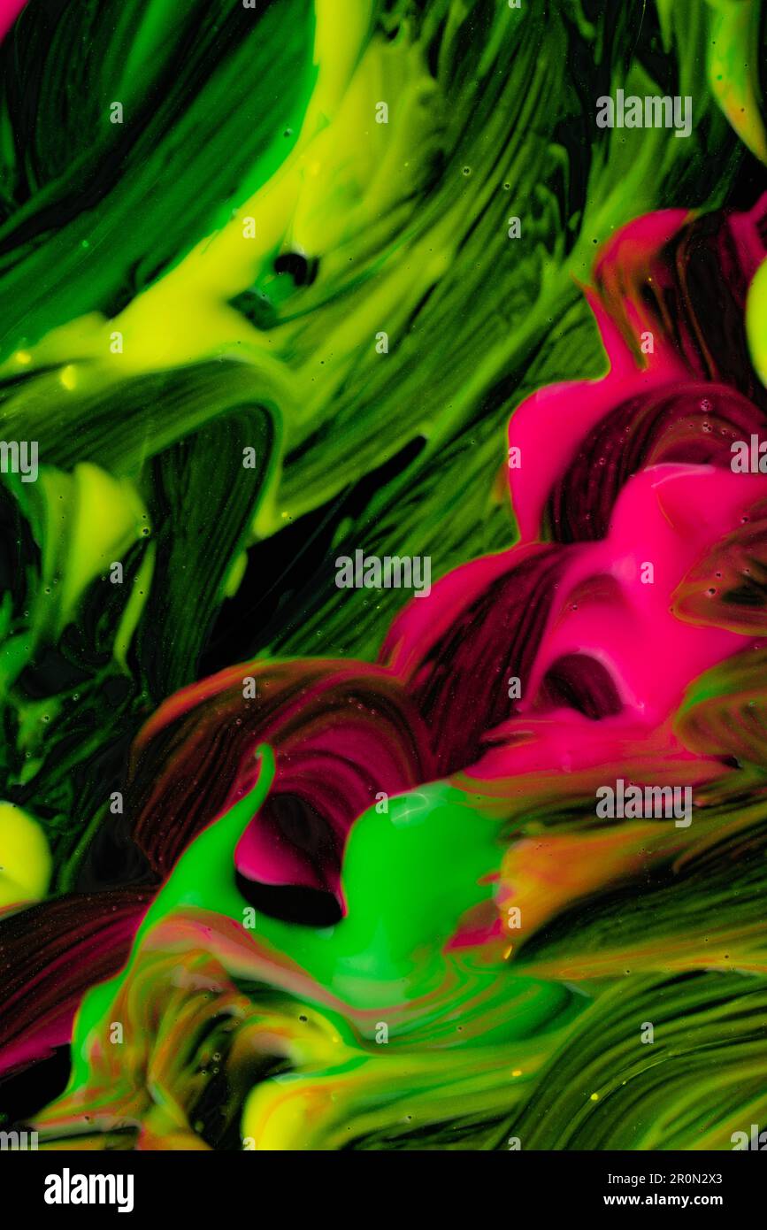 Closeup shot of spills of thick pigment of various colors mixing on ...