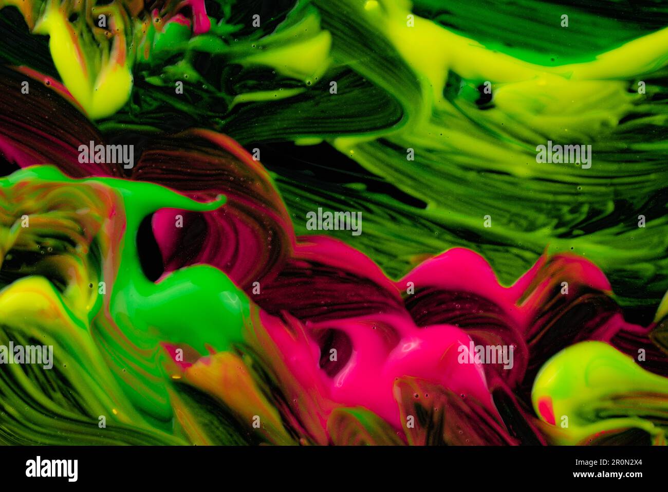 Closeup shot of spills of thick pigment of various colors mixing on ...