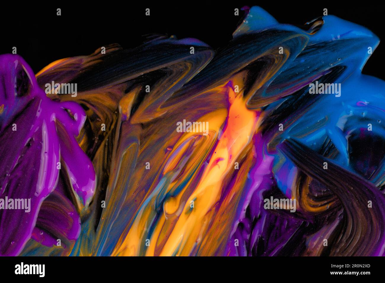Closeup shot of spills of thick pigment of various colors mixing on ...