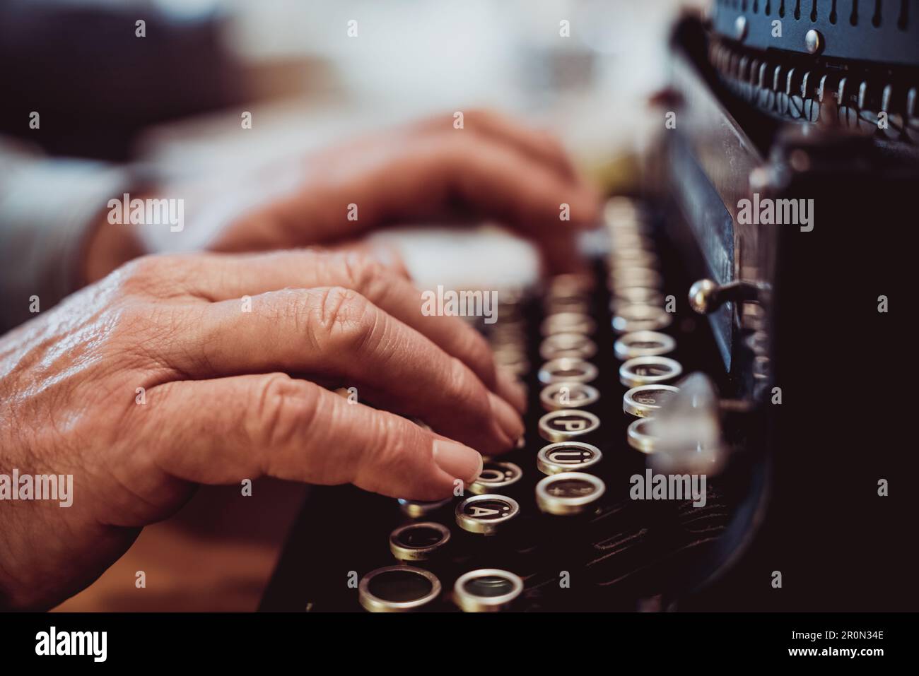 shot of hands of anonymous elderly person typing on keyboard of vintage ...