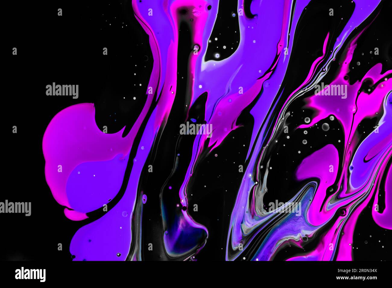 Close-up shot of thick paint of various bright colors flowing down and ...