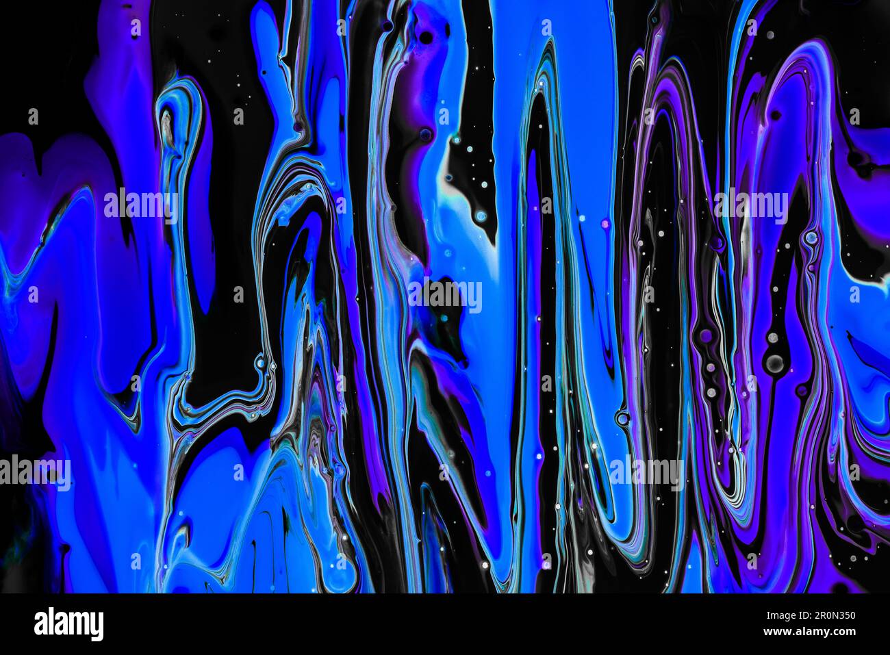 Close-up shot of thick paint of various bright colors flowing down and ...