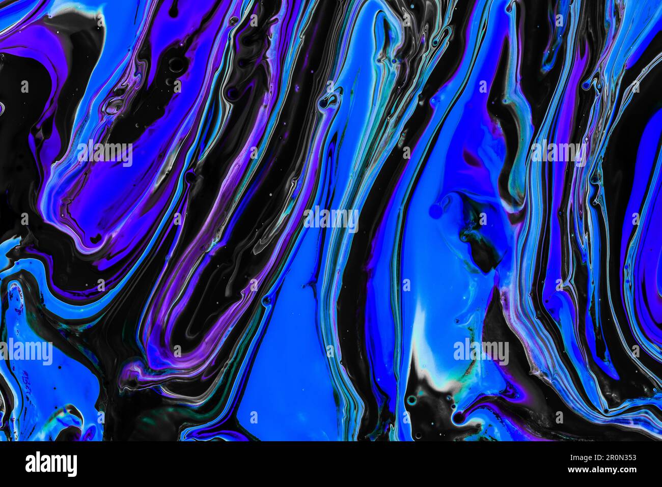 Close-up shot of thick paint of various bright colors flowing down and ...