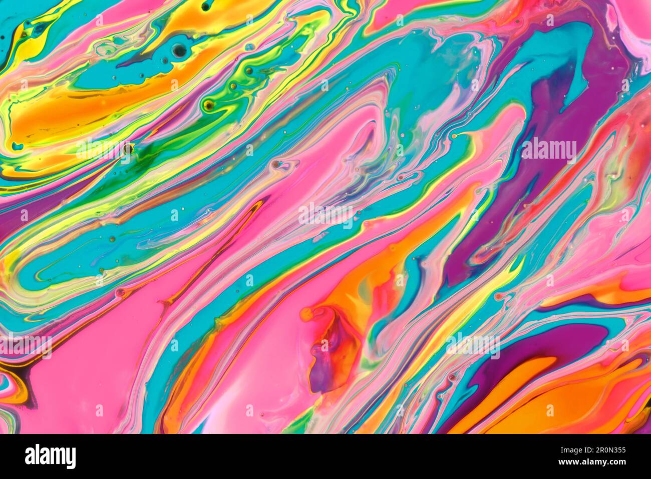 Close-up shot of thick paint of various bright colors flowing down and ...