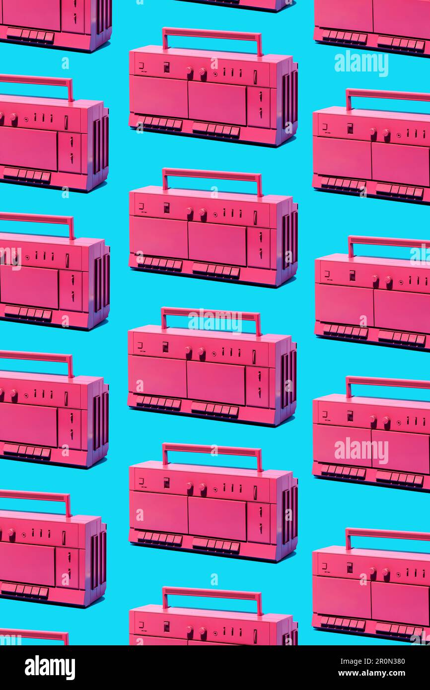 Pattern of set of similar pink retro tape recorder against blue ...