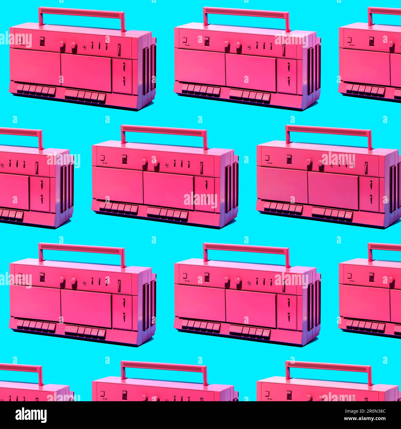 Pattern of set of similar pink retro tape recorder against blue ...