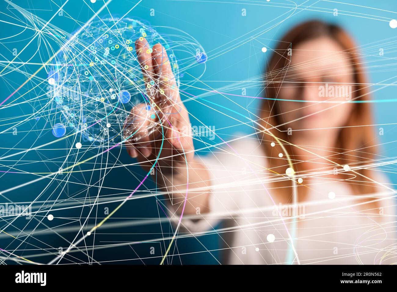 A young woman using a futuristic touch screen device with a bright ...