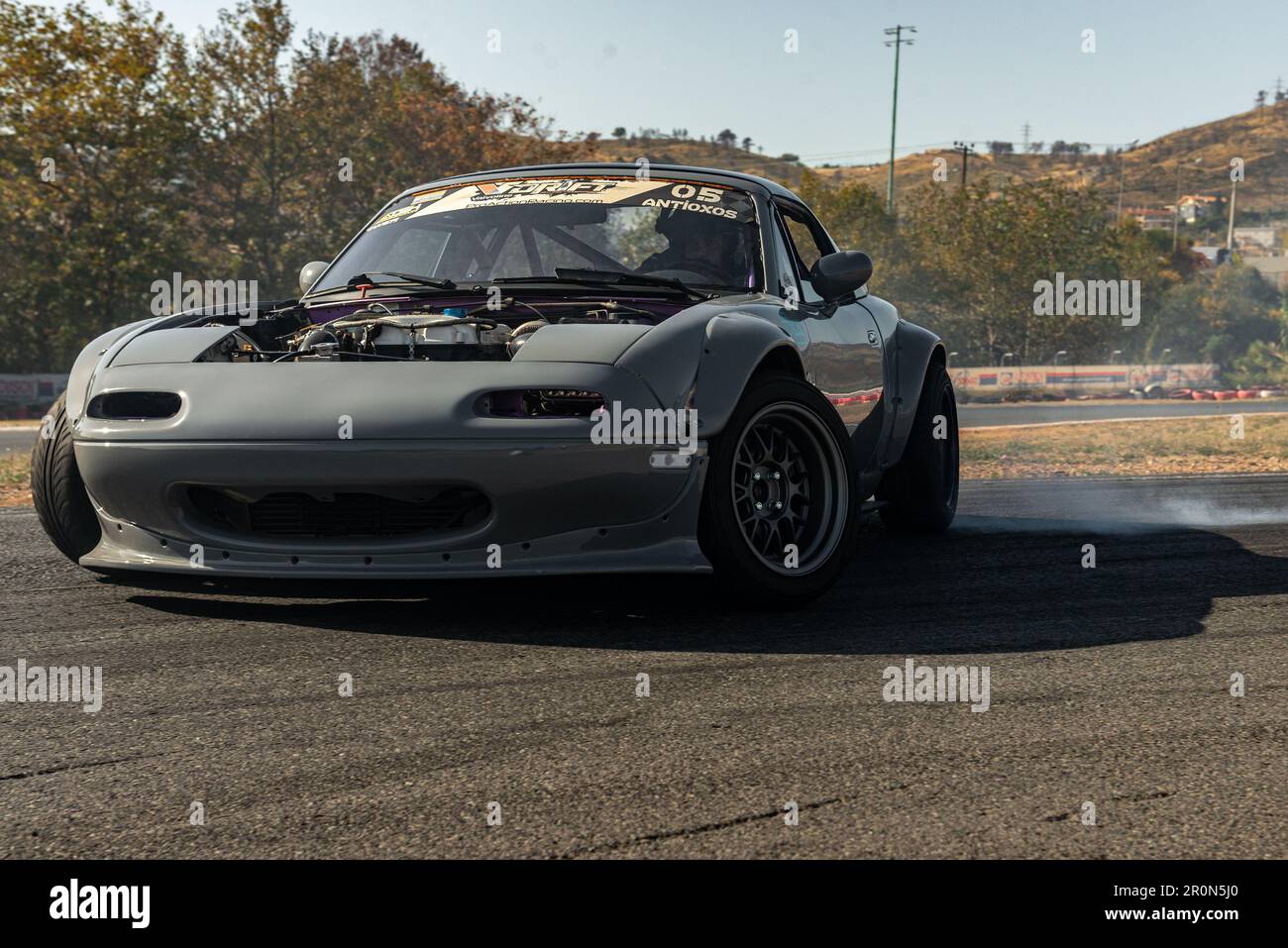 A shot of a Mazda Miata race car doing a burnout on a racetrack Stock ...