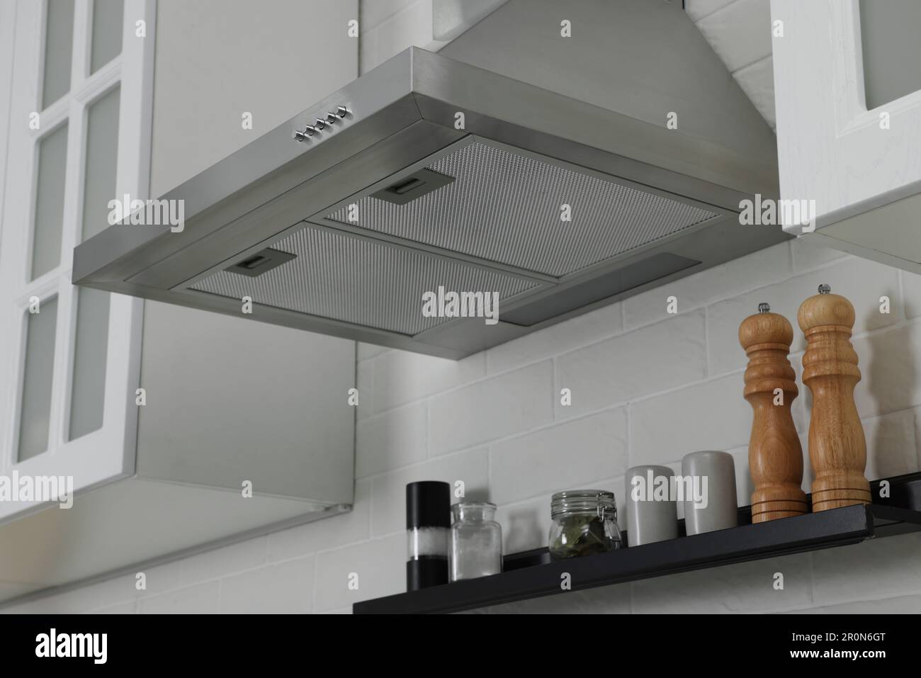 Modern range hood over shelf with spices in kitchen Stock Photo - Alamy