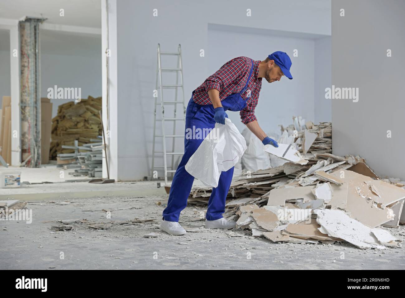 Construction worker with used building materials in room prepared for ...