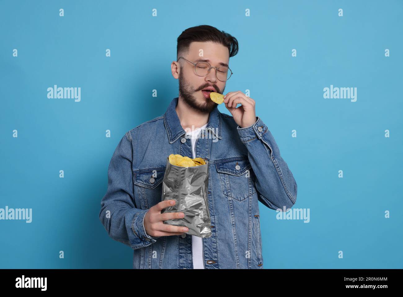 Young man eating potato chips hi-res stock photography and images - Alamy