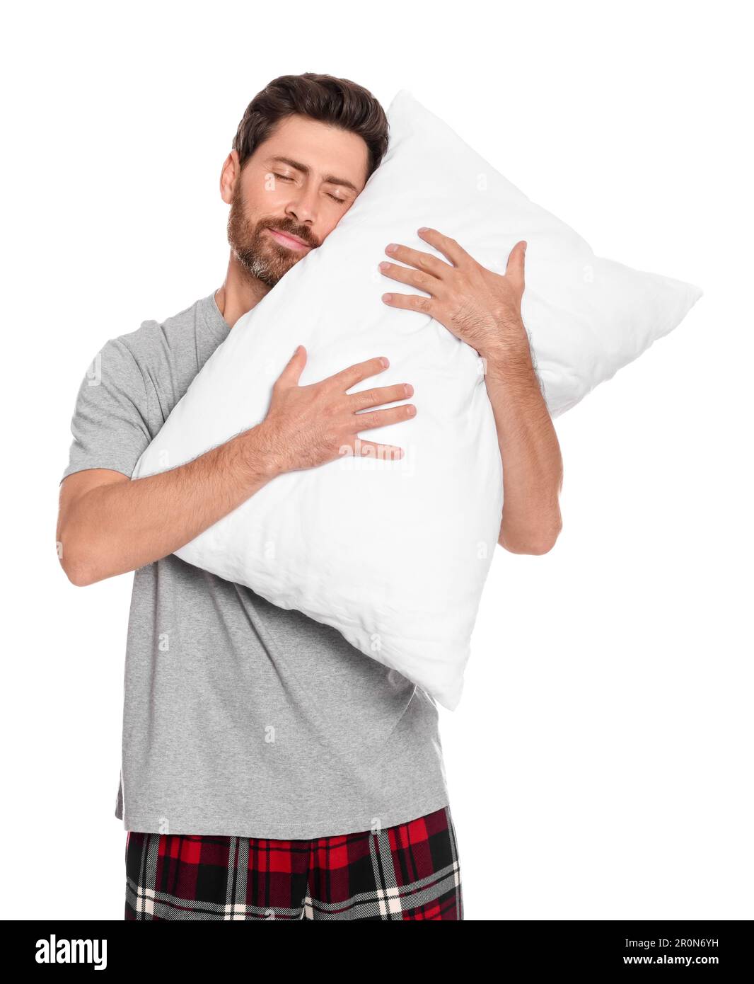 Sleepy handsome man hugging soft pillow on white background Stock Photo ...