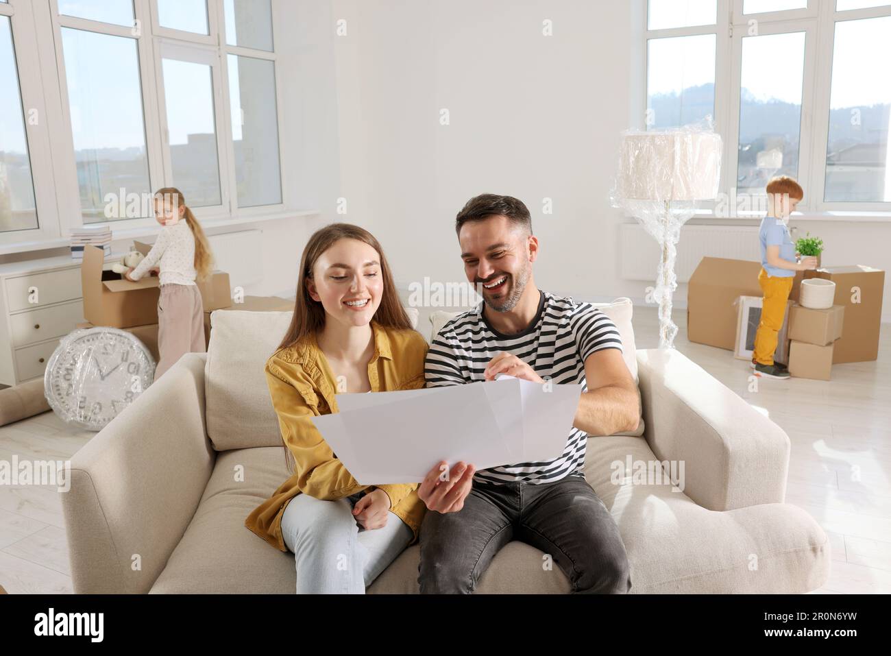 Family settling into home. Happy wife with husband choosing interior ...