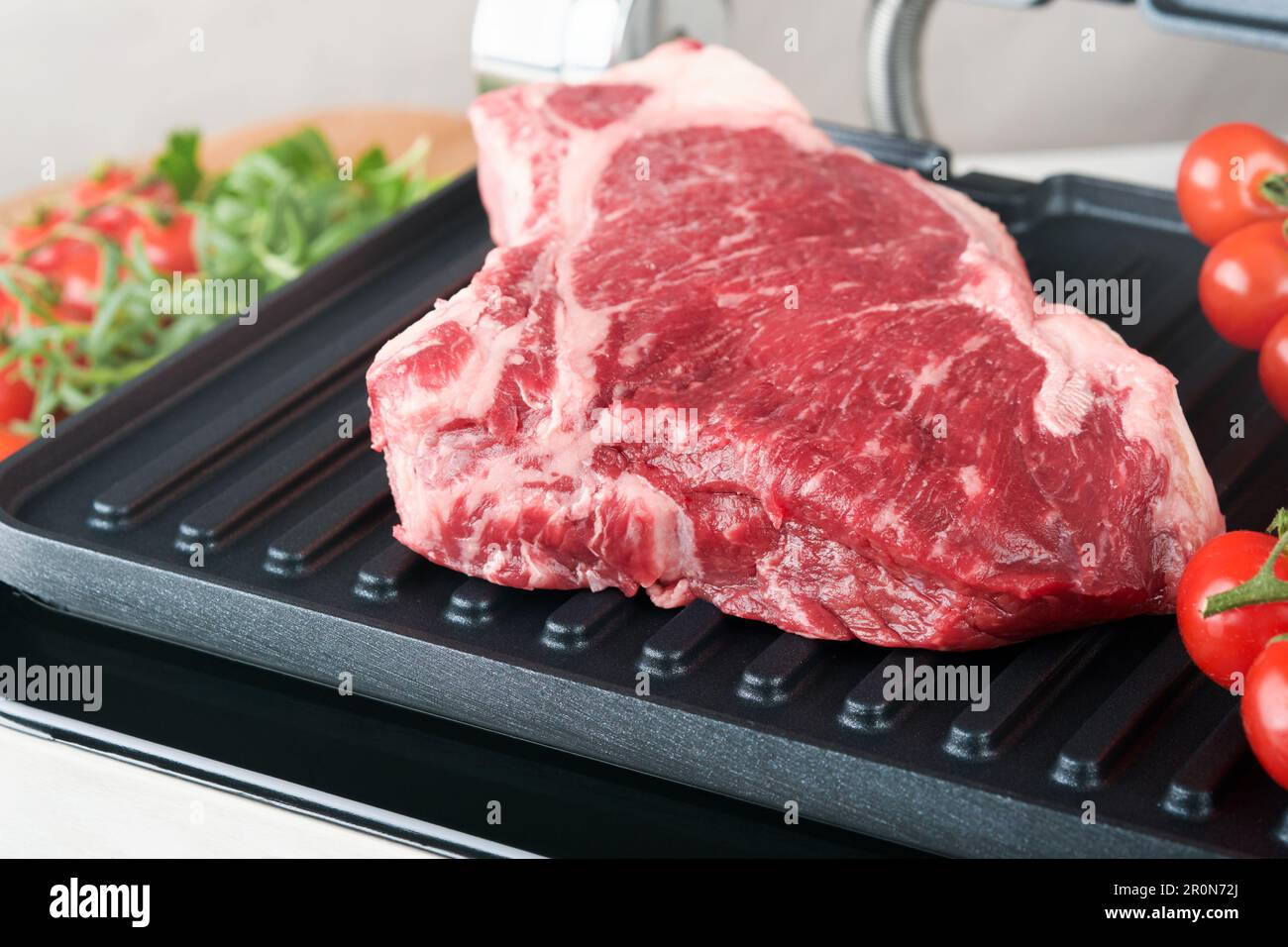 Raw prime steaks on electric grill. Black angus prime meat steaks ...