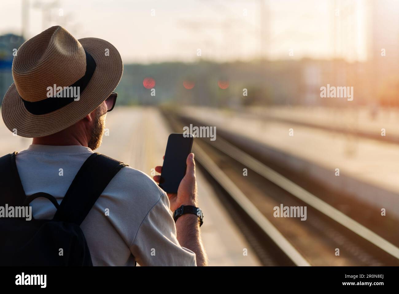 Traveler man wearing straw hat using has mobile phone while standing on ...