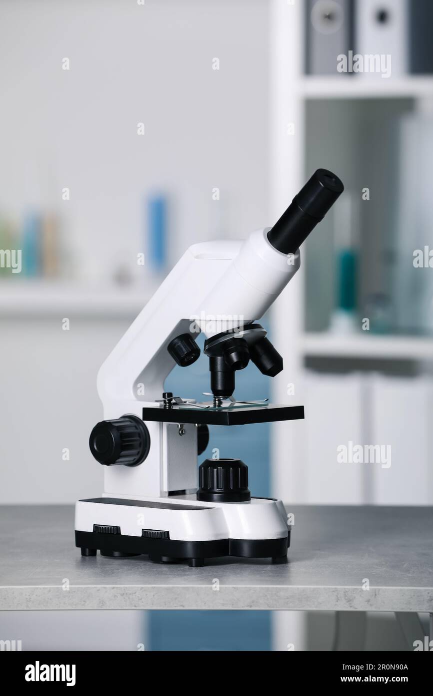 Modern medical microscope on grey table in laboratory Stock Photo - Alamy