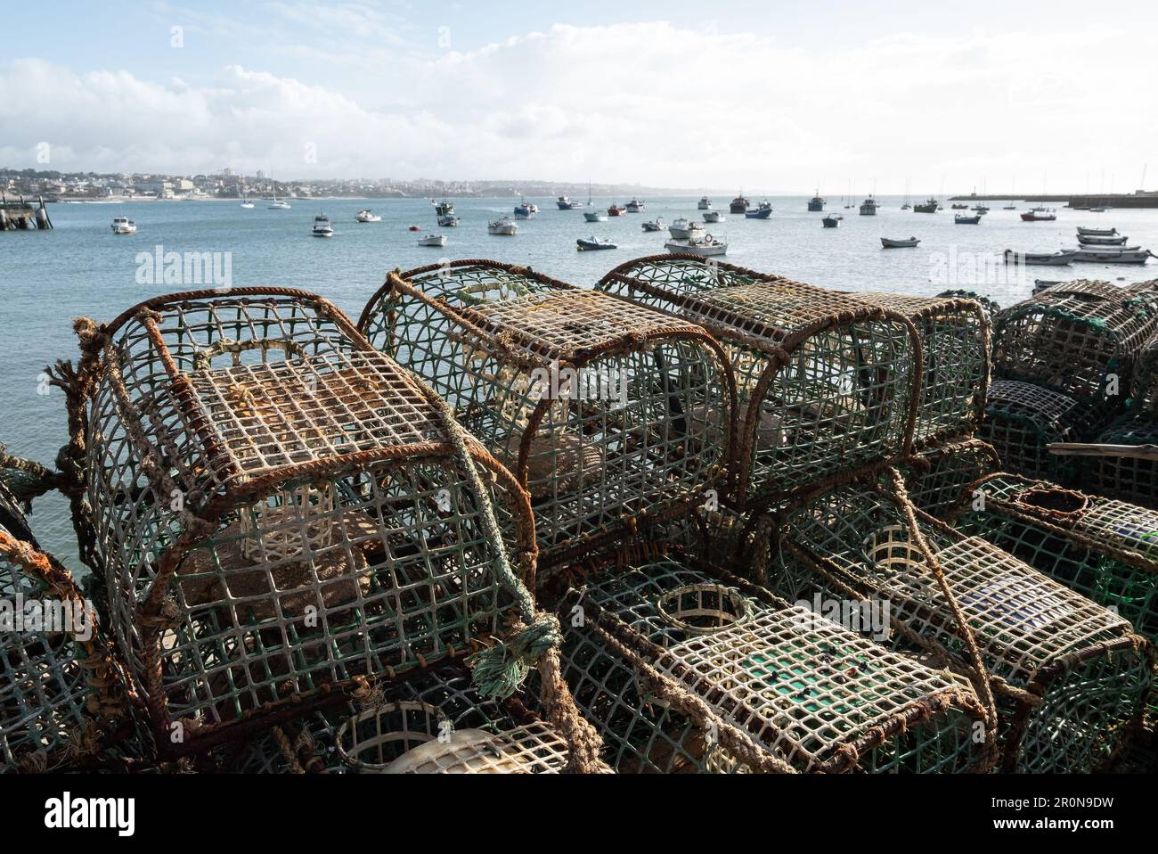 Stacked fishing baskets and fishing boats in the fishing port of ...