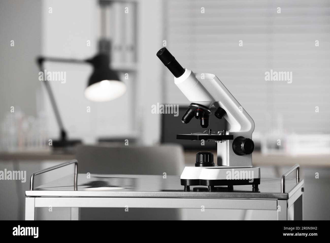 Modern medical microscope on metal table in laboratory, space for text ...