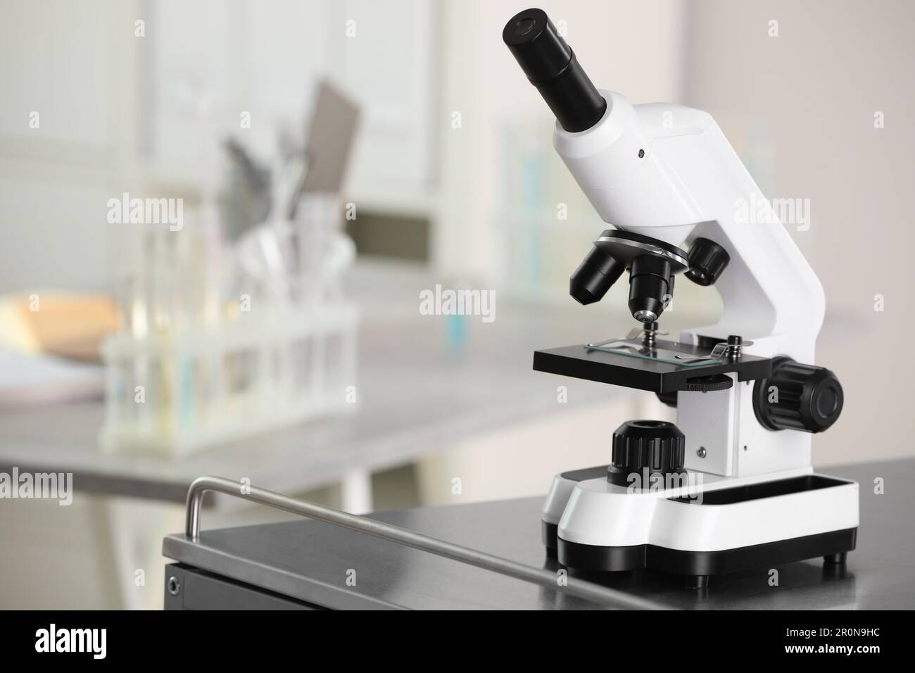 Modern medical microscope on metal table in laboratory, space for text ...