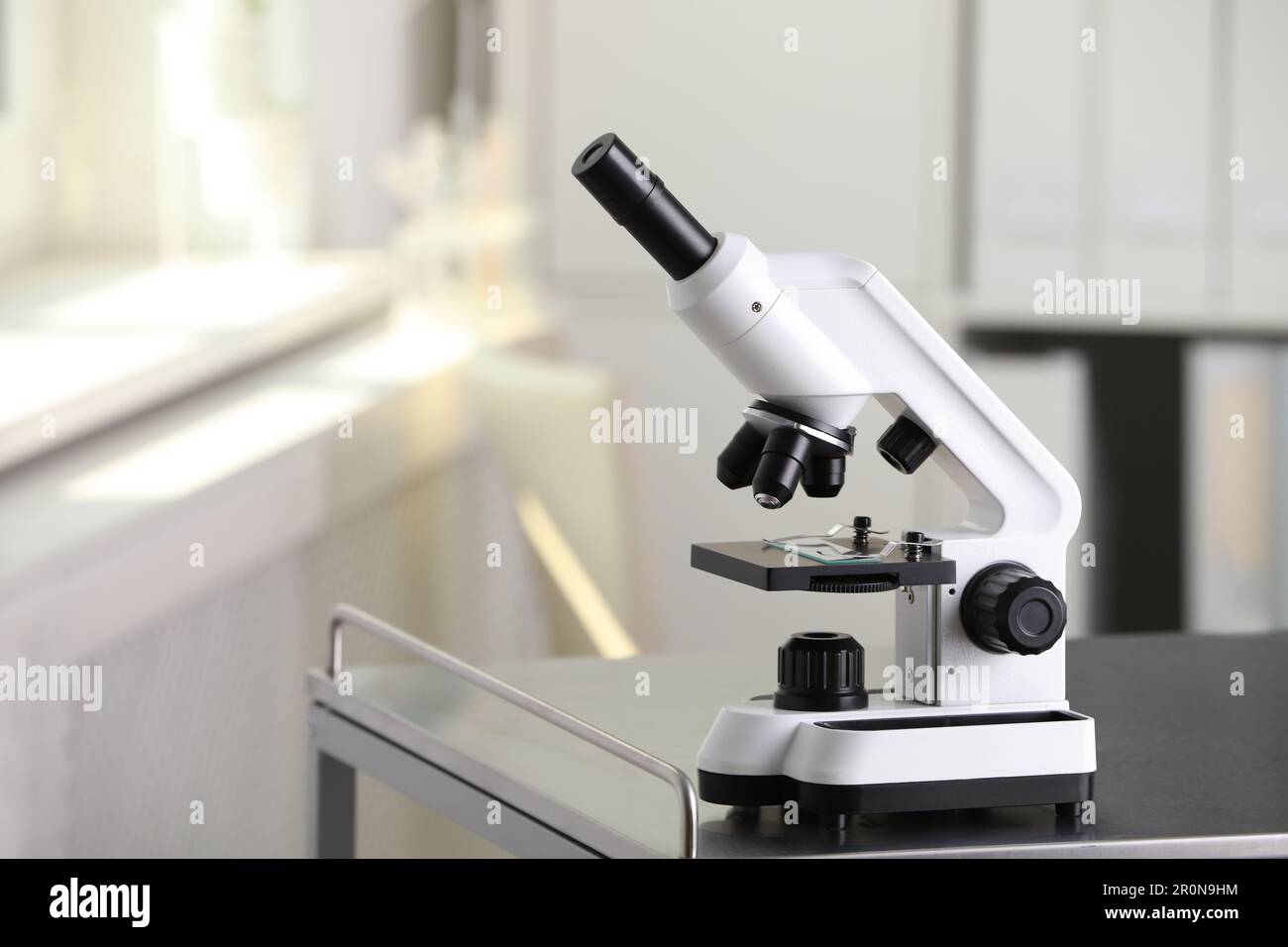 Modern medical microscope on metal table in laboratory, space for text ...