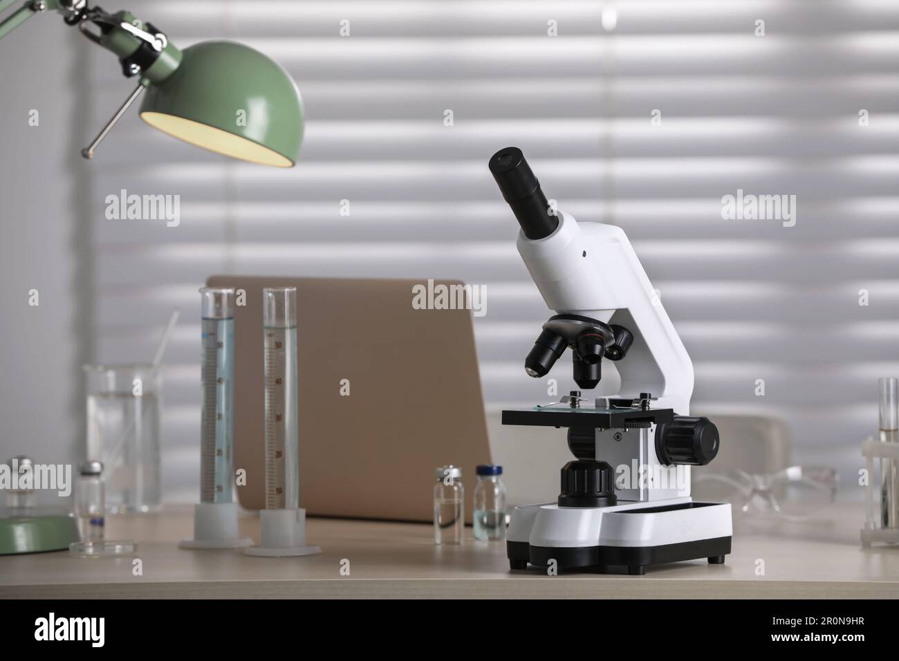 Modern medical microscope on wooden table in laboratory Stock Photo - Alamy