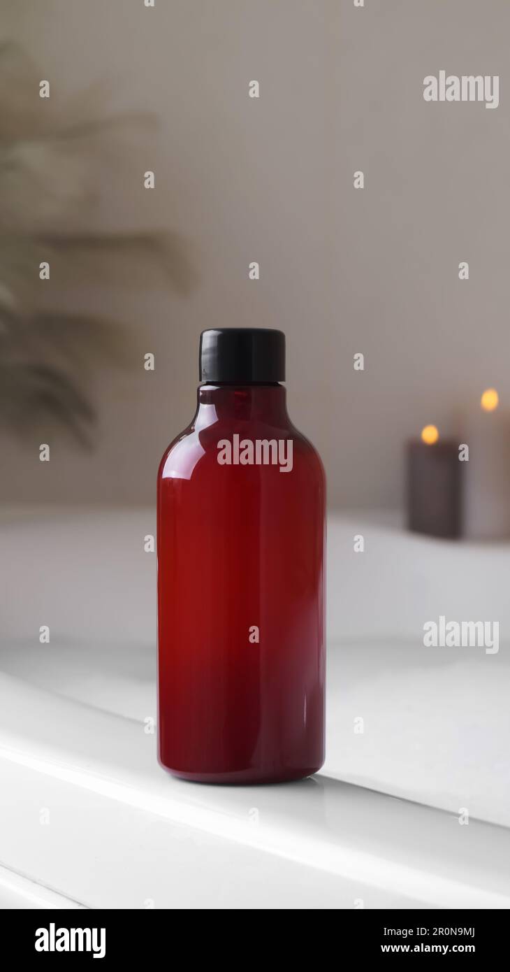 Red bottle of bubble bath on tub indoors Stock Photo - Alamy