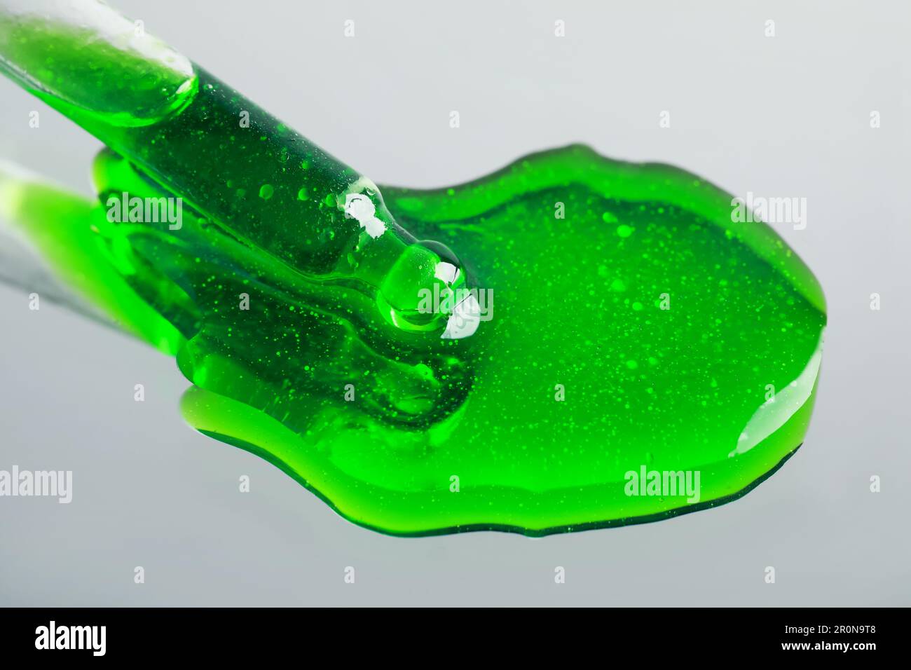 Dripping green serum from pipette on mirror, closeup Stock Photo - Alamy