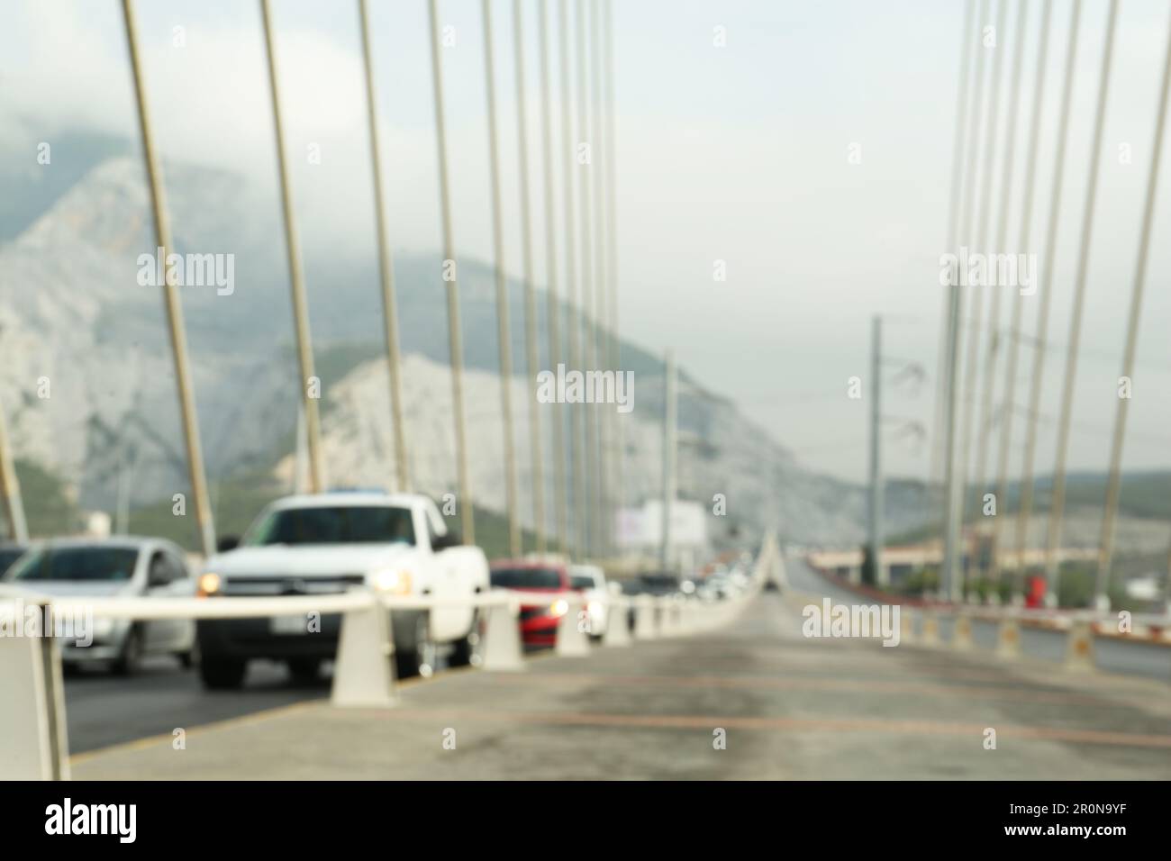 Blurred view of modern bridge and cars near mountain Stock Photo - Alamy