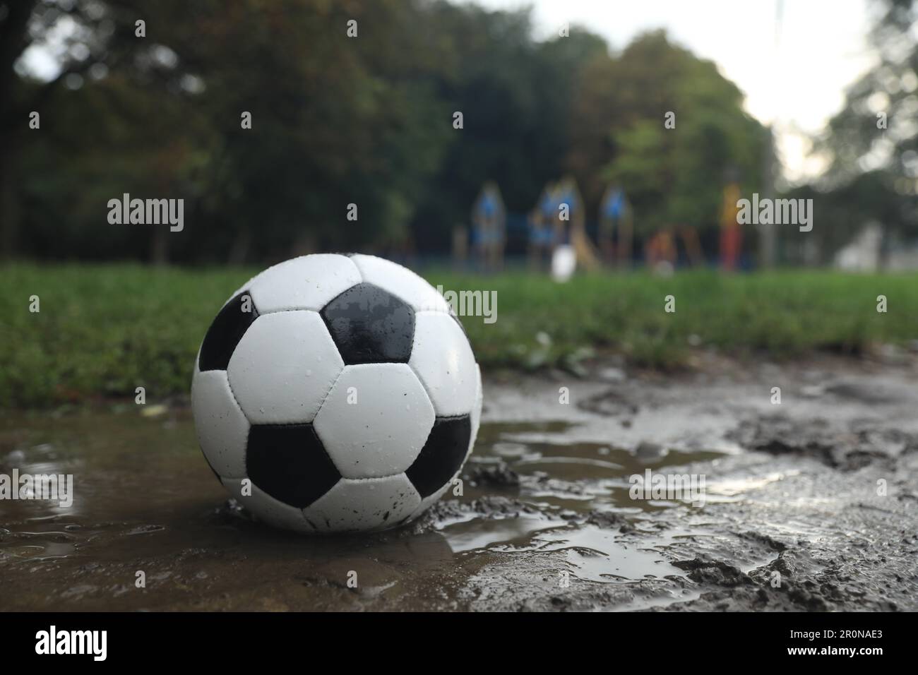 Leather soccer ball in puddle outdoors, space for text Stock Photo - Alamy