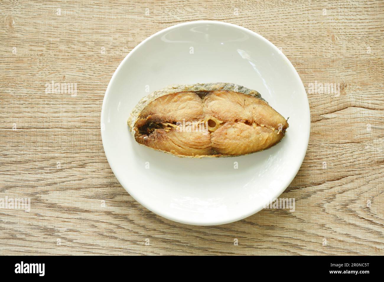 chop fried salty dry Indo-Pacific king mackerel fish on plate Stock ...