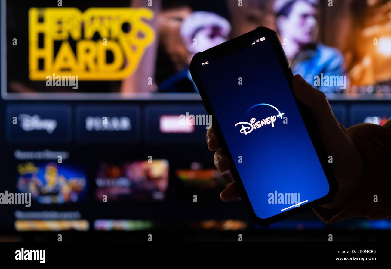 A person's hand holding a smartphone displaying the Disney logo Stock ...