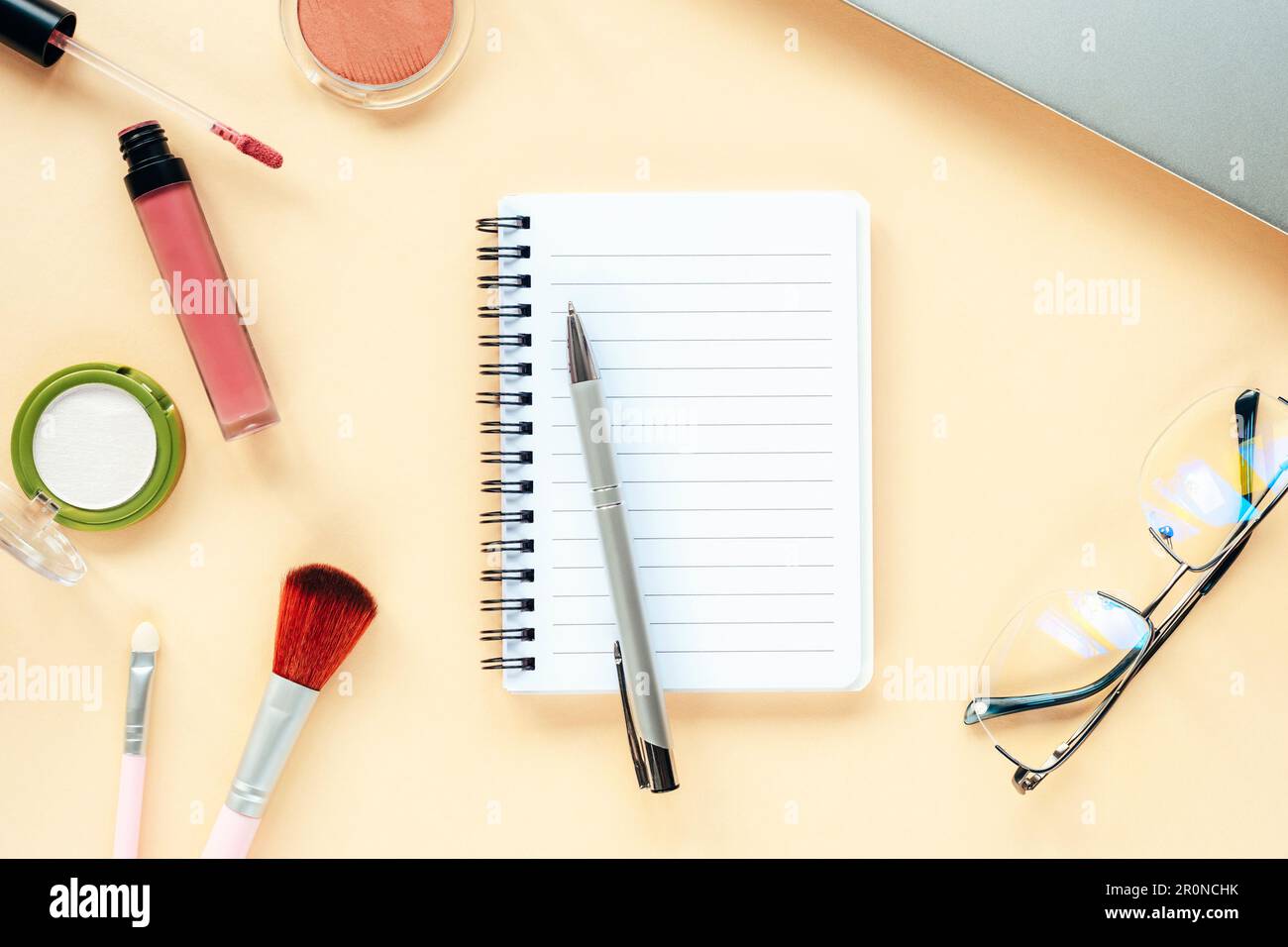 Blank notepad with pen, glasses, notebook and makeup cosmetics on beige ...